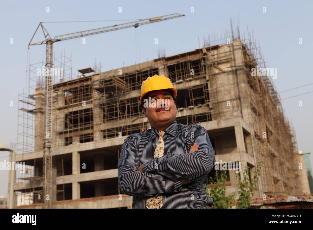Architect standing with his arms crossed at construction site Stock ...