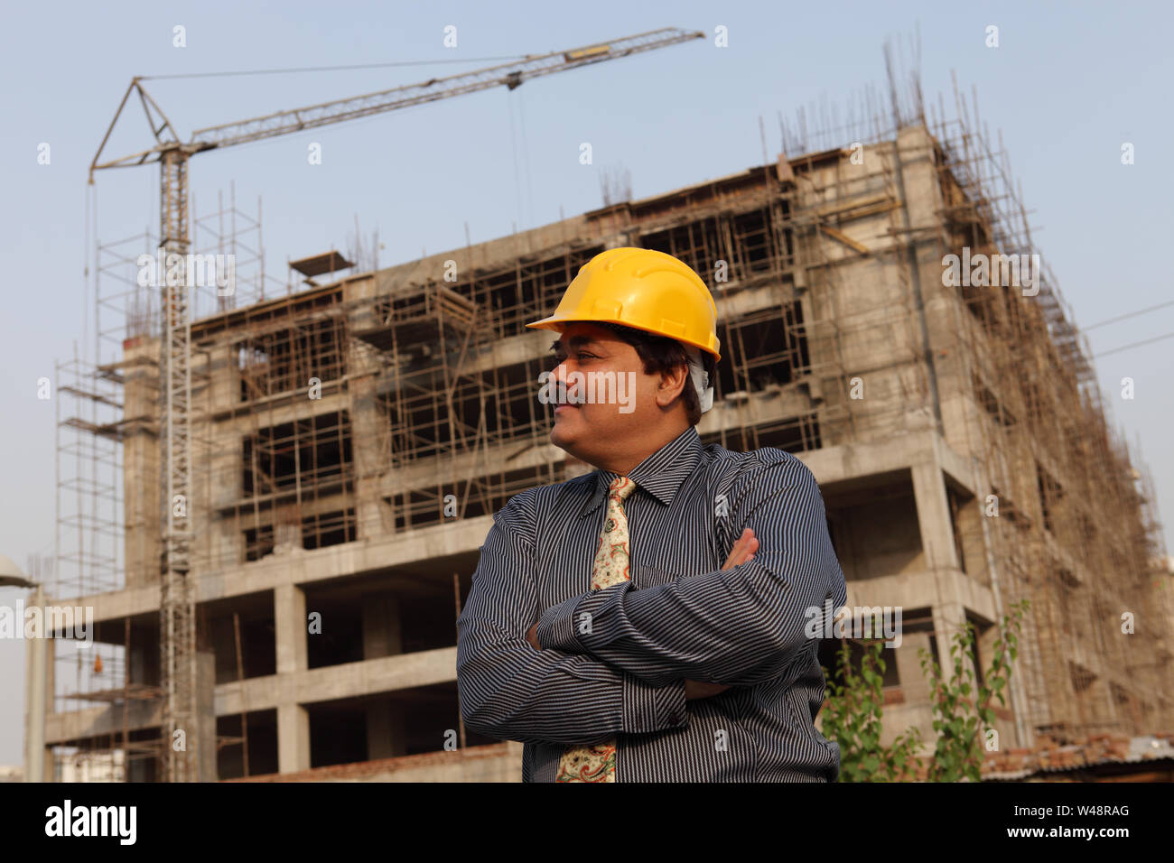 Architect standing with his arms crossed at construction site Stock ...