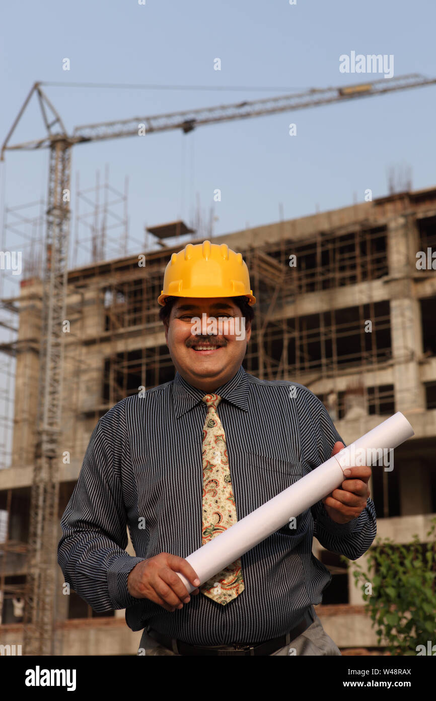 Architect holding blueprint at construction site Stock Photo - Alamy