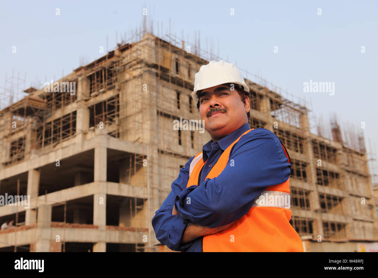 Architect with his arms crossed at construction site Stock Photo - Alamy