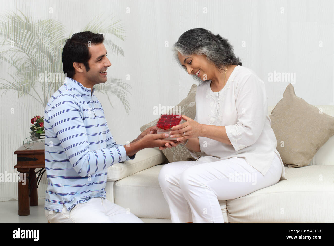 Man giving gift to his mother Stock Photo - Alamy