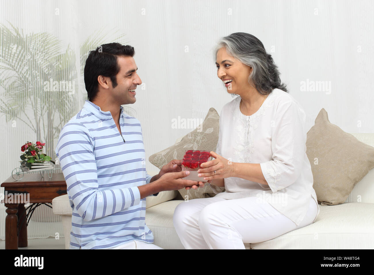 Man giving gift to his mother Stock Photo - Alamy