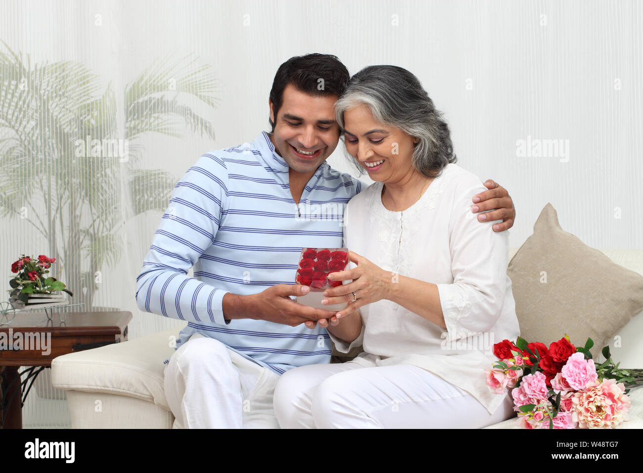 Man giving gift to his mother Stock Photo - Alamy