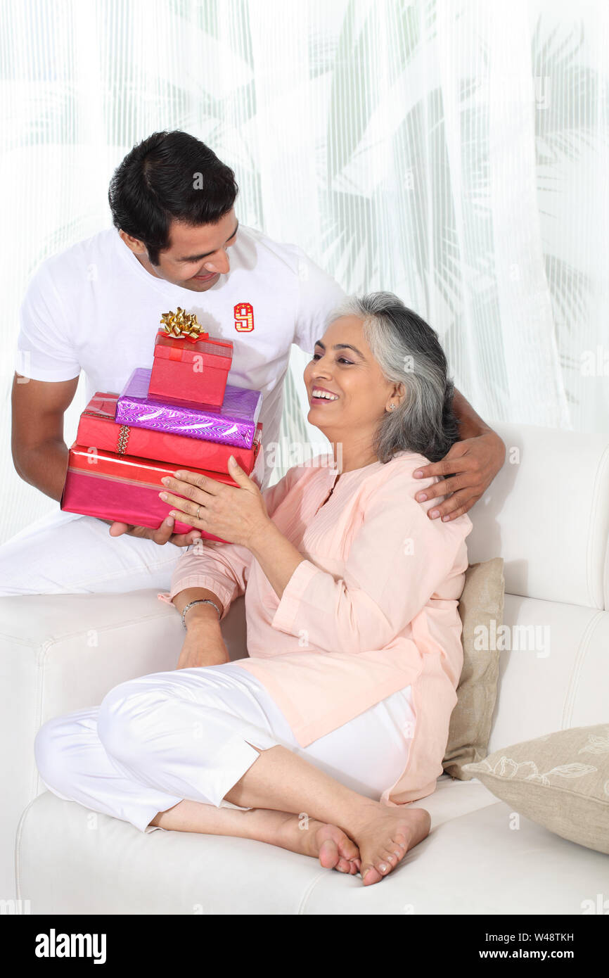 Man giving gifts to his mother Stock Photo - Alamy