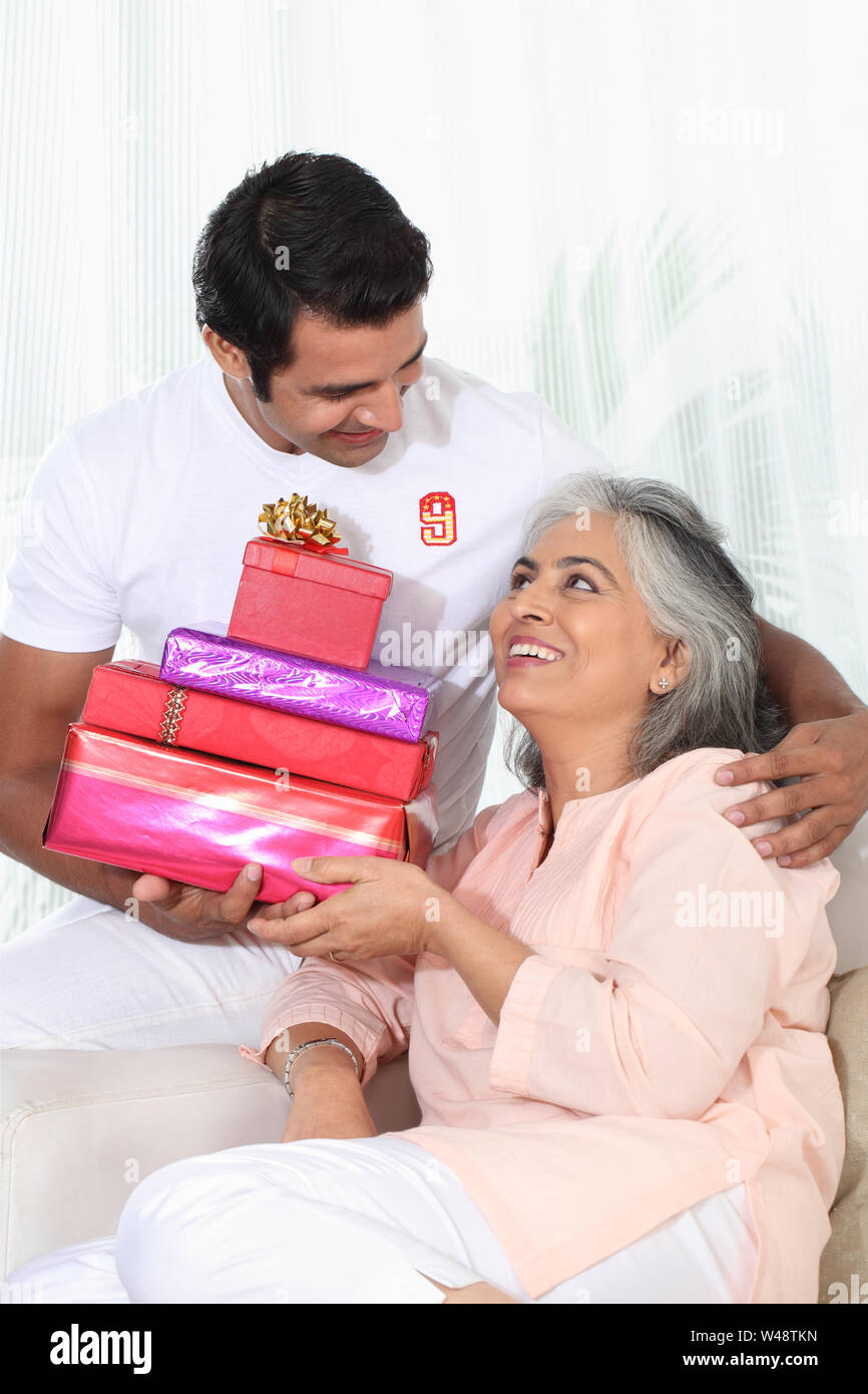 Man giving gifts to his mother Stock Photo - Alamy
