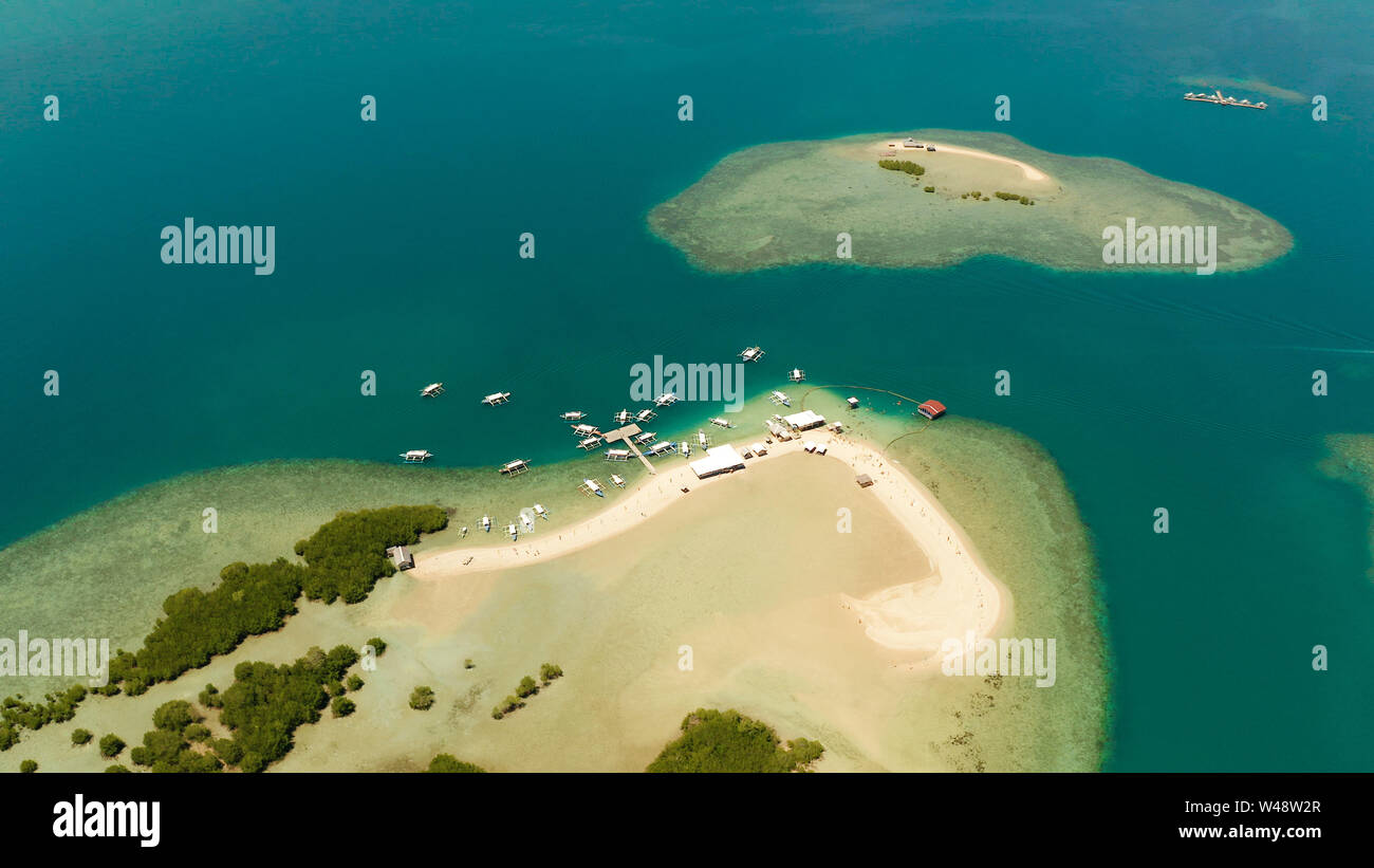 Luli island and sandy beach with tourists, sand bar surrounded by coral ...