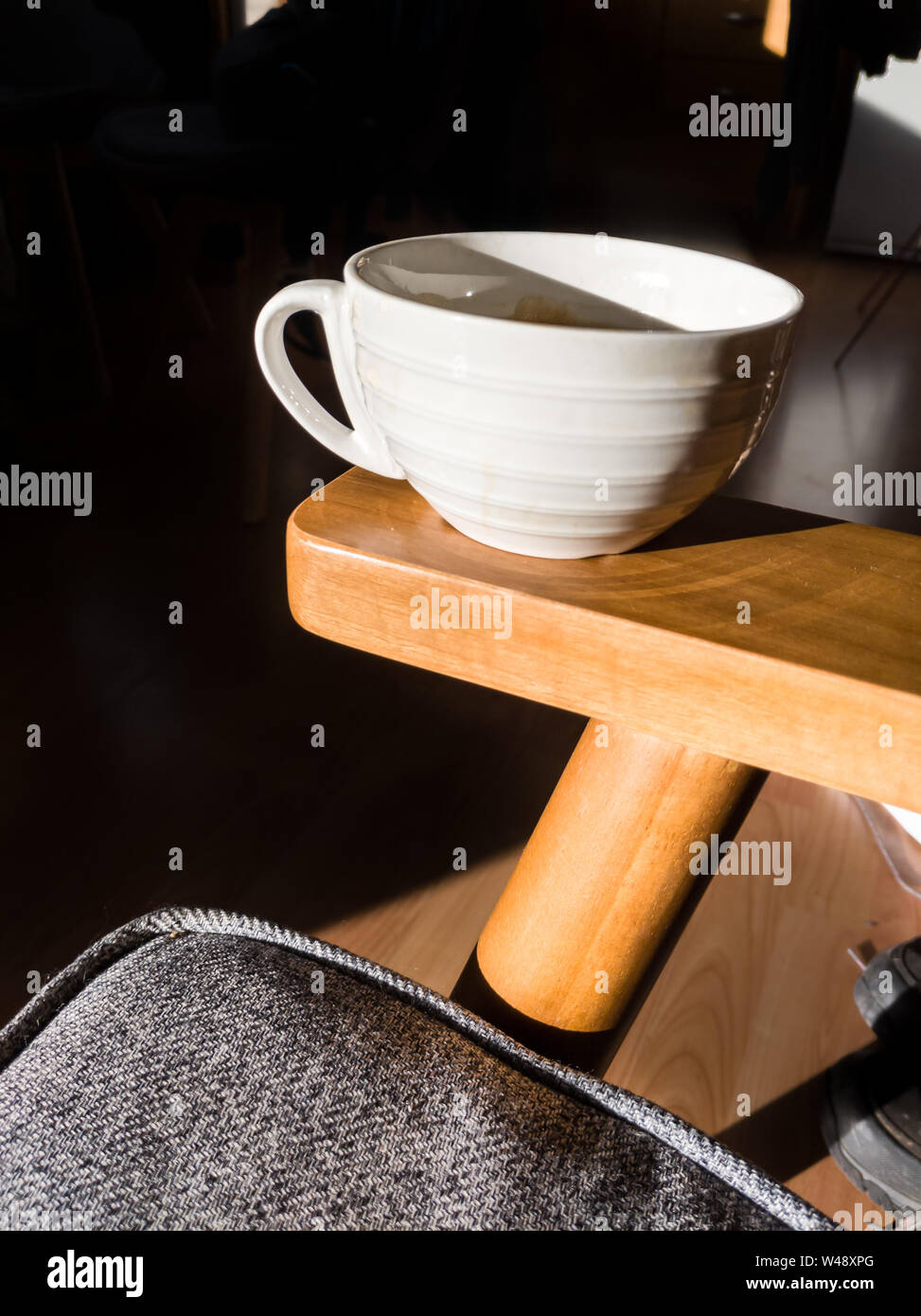 Morning coffee cup on the wooden arm of a chair Stock Photo - Alamy