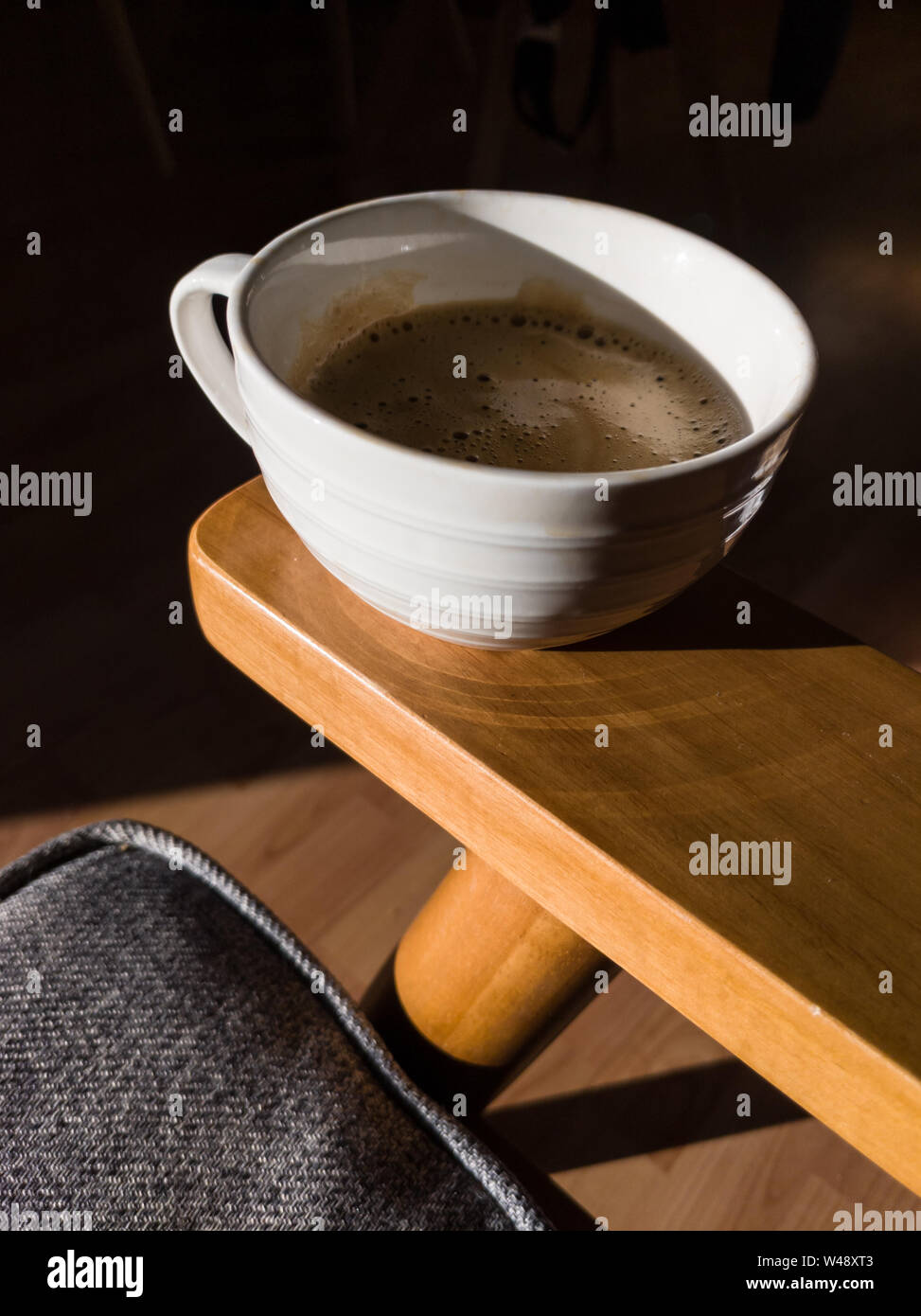 Morning coffee cup on the wooden arm of a chair Stock Photo - Alamy