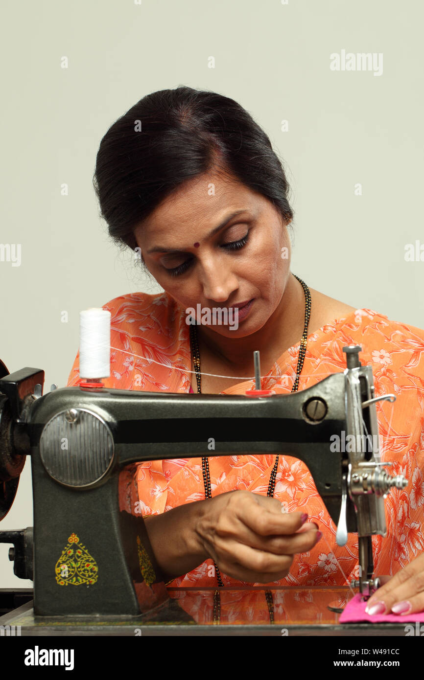 Indian woman using sewing machine Stock Photo - Alamy