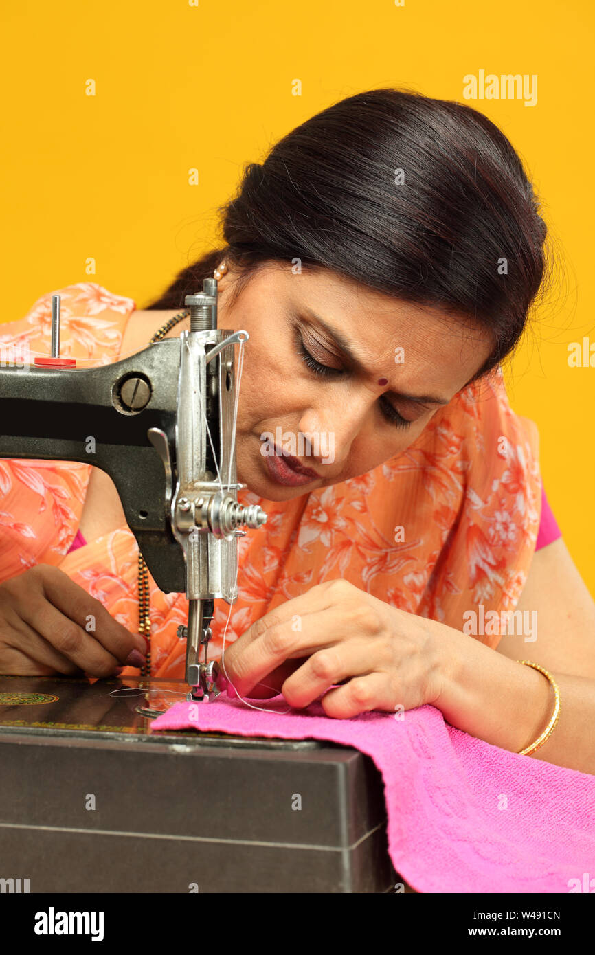 Indian woman using sewing machine Stock Photo - Alamy