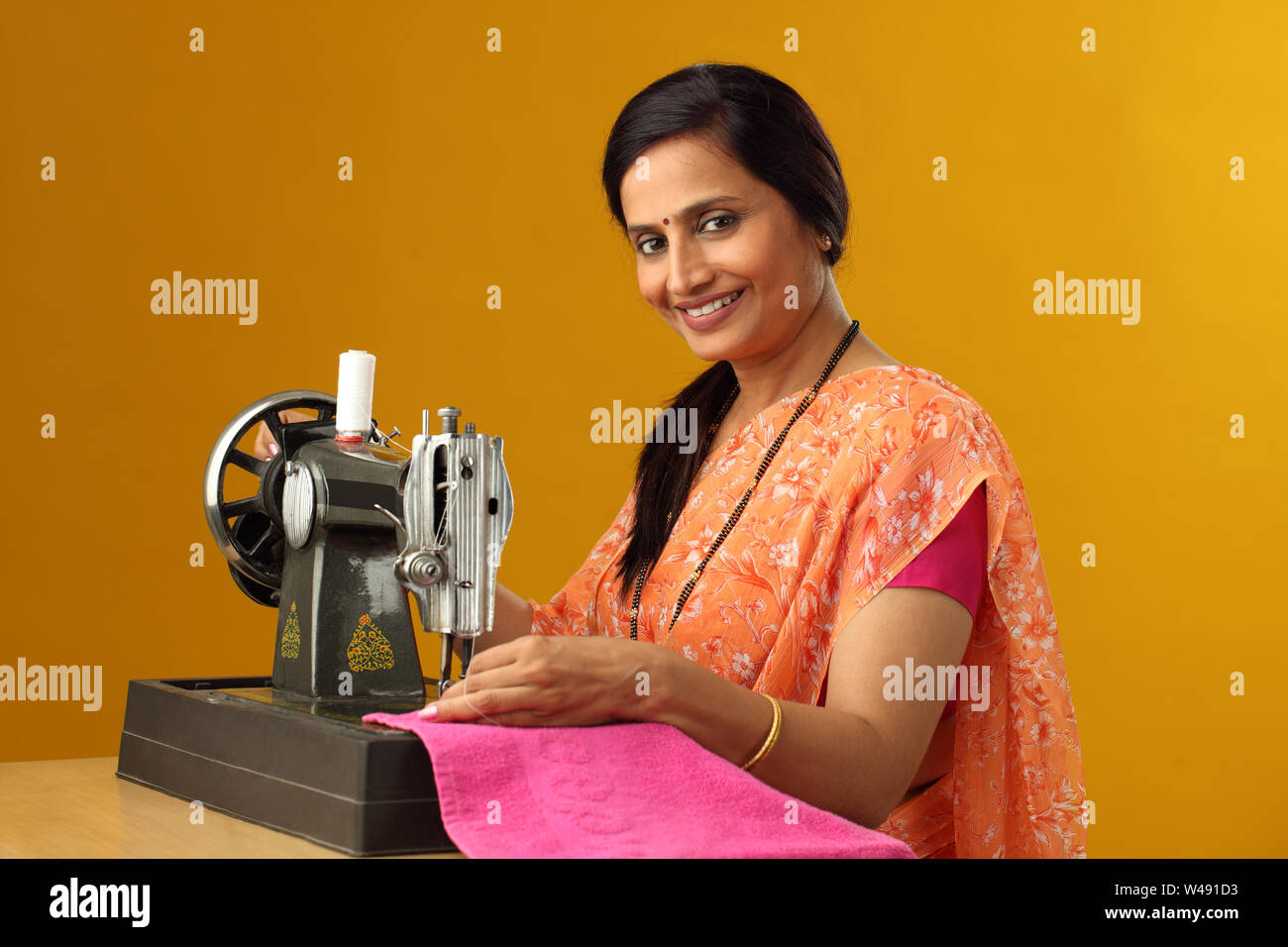 Woman using sewing machine Stock Photo - Alamy
