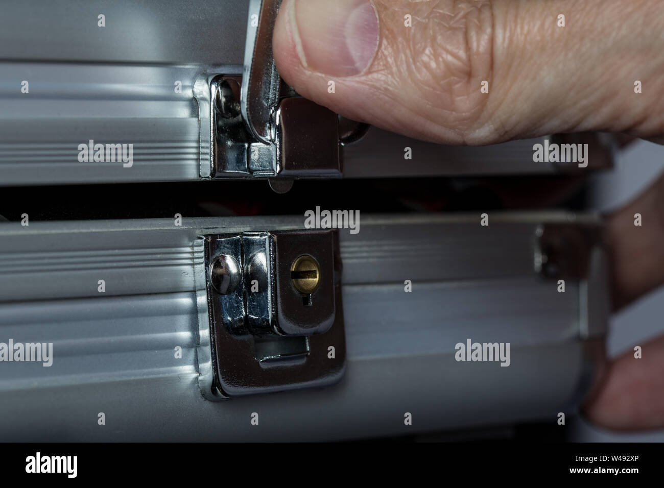 Macro of human hand opening or closing metal briefcase Stock Photo - Alamy