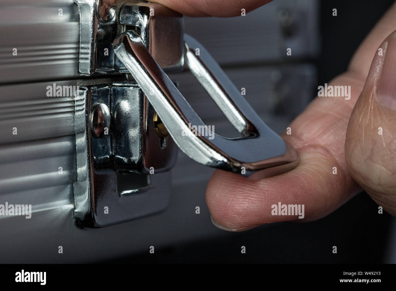 Macro of human hand opening or closing metal briefcase Stock Photo - Alamy
