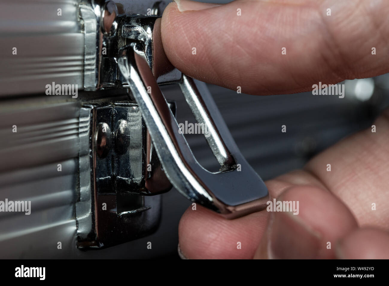 Macro of human hand opening or closing metal briefcase Stock Photo - Alamy