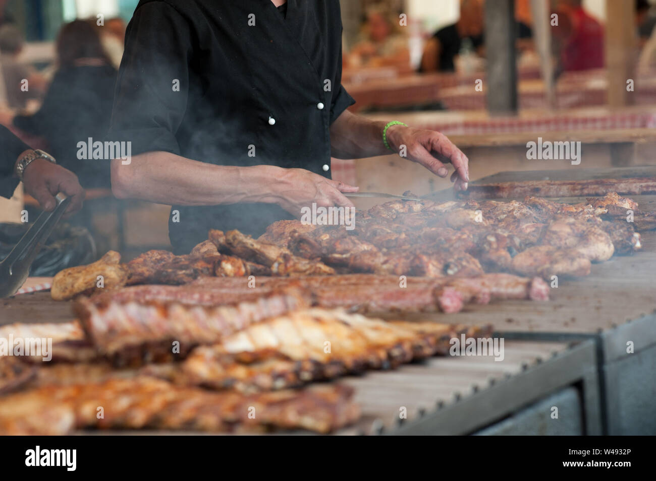 Man grilling an assortment of meat and chiken on a large barbecue Stock ...