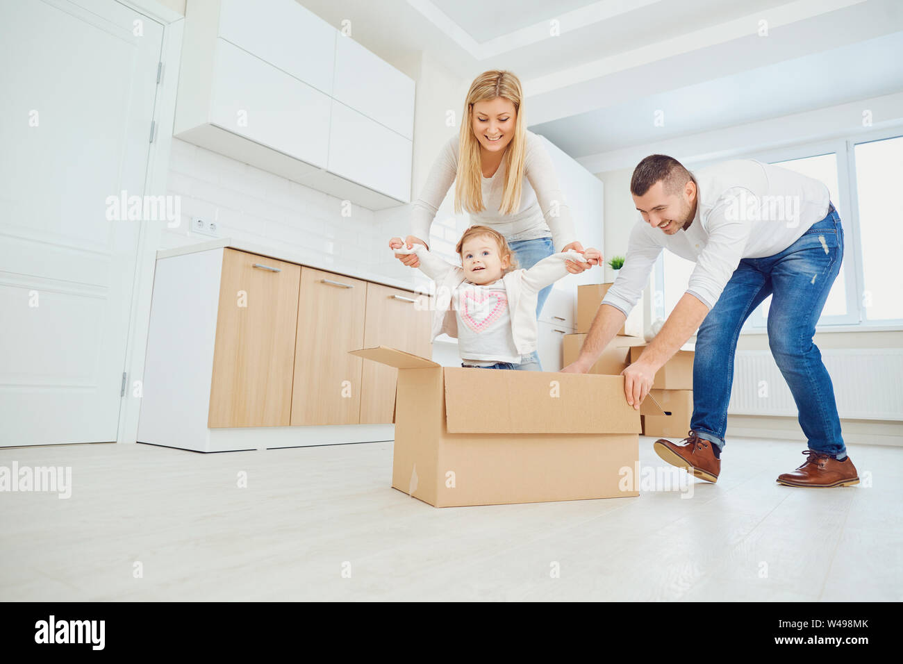 Happy family unpacking boxes at new home Stock Photo - Alamy