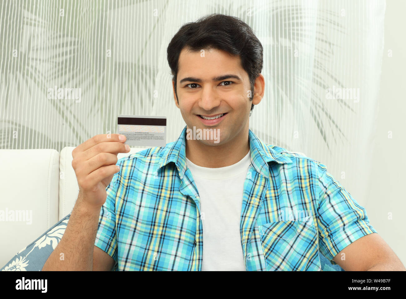 Man showing credit card and smiling Stock Photo - Alamy