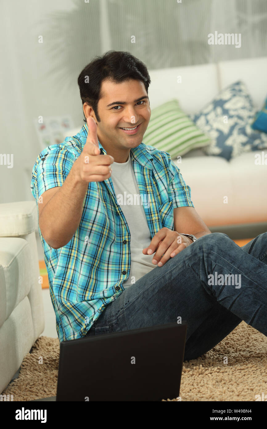 Portrait of a man making gun sign and smiling Stock Photo - Alamy