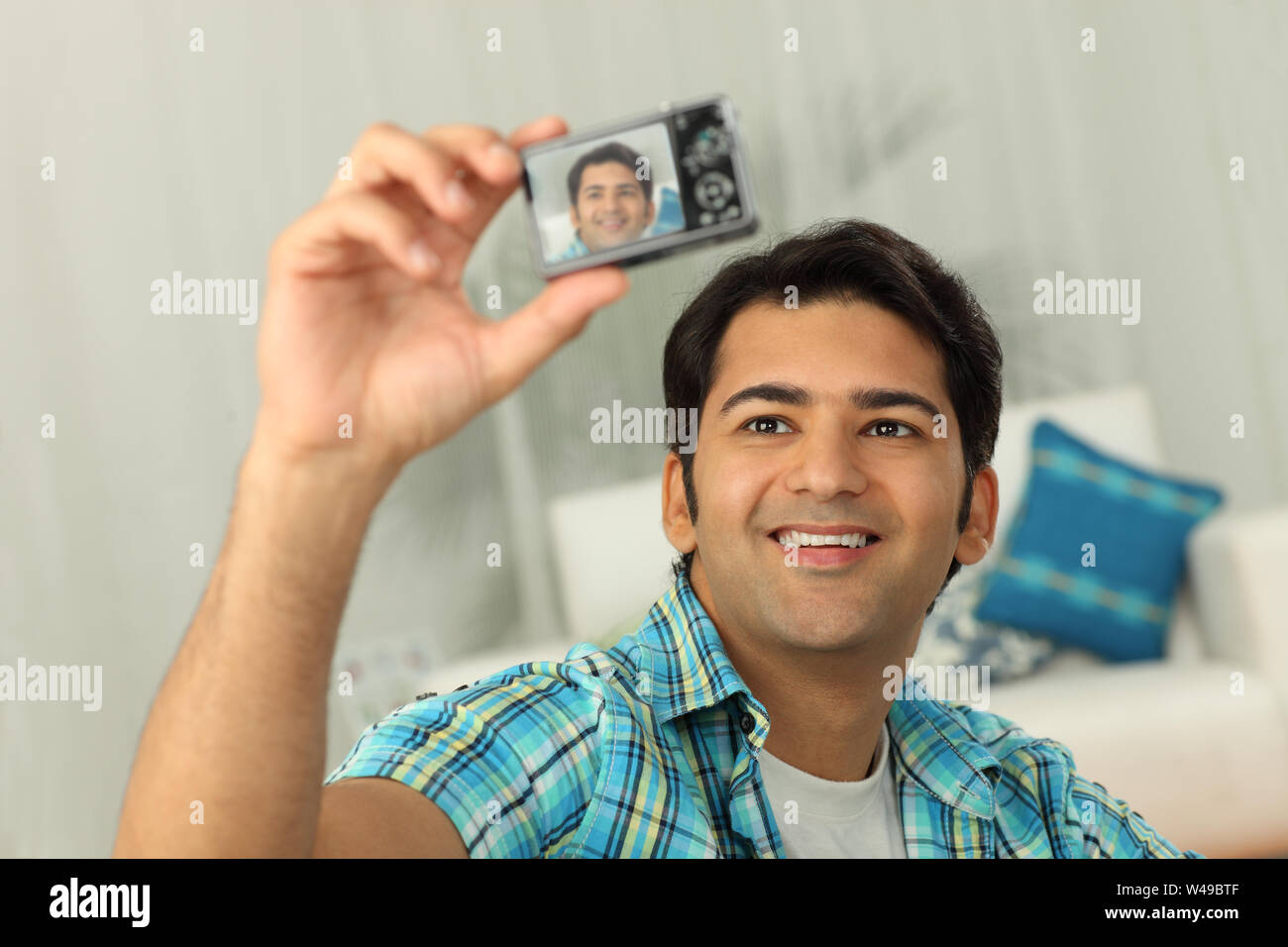 Indian young man taking picture with digital camera Stock Photo - Alamy