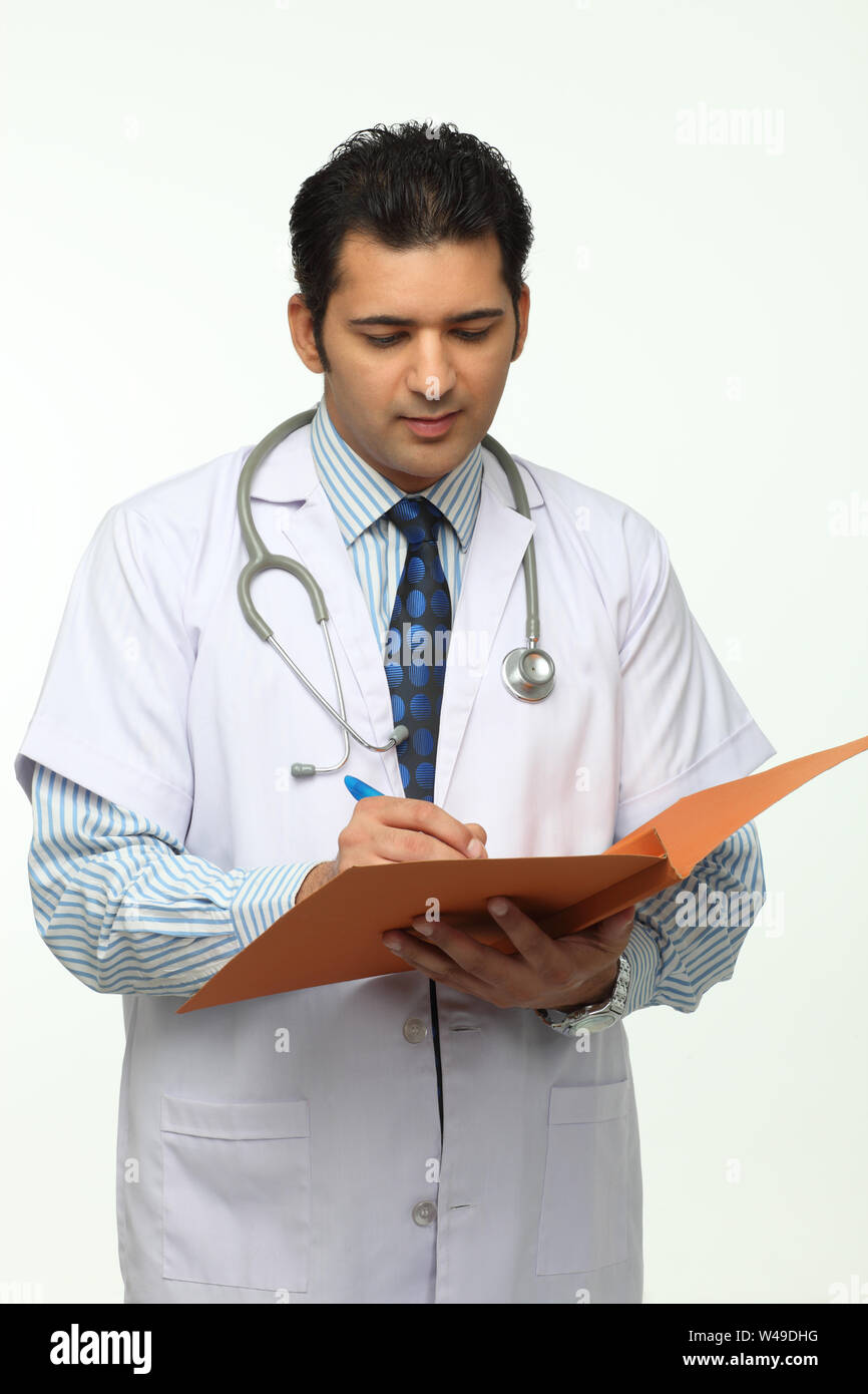 Male doctor writing in a file Stock Photo - Alamy