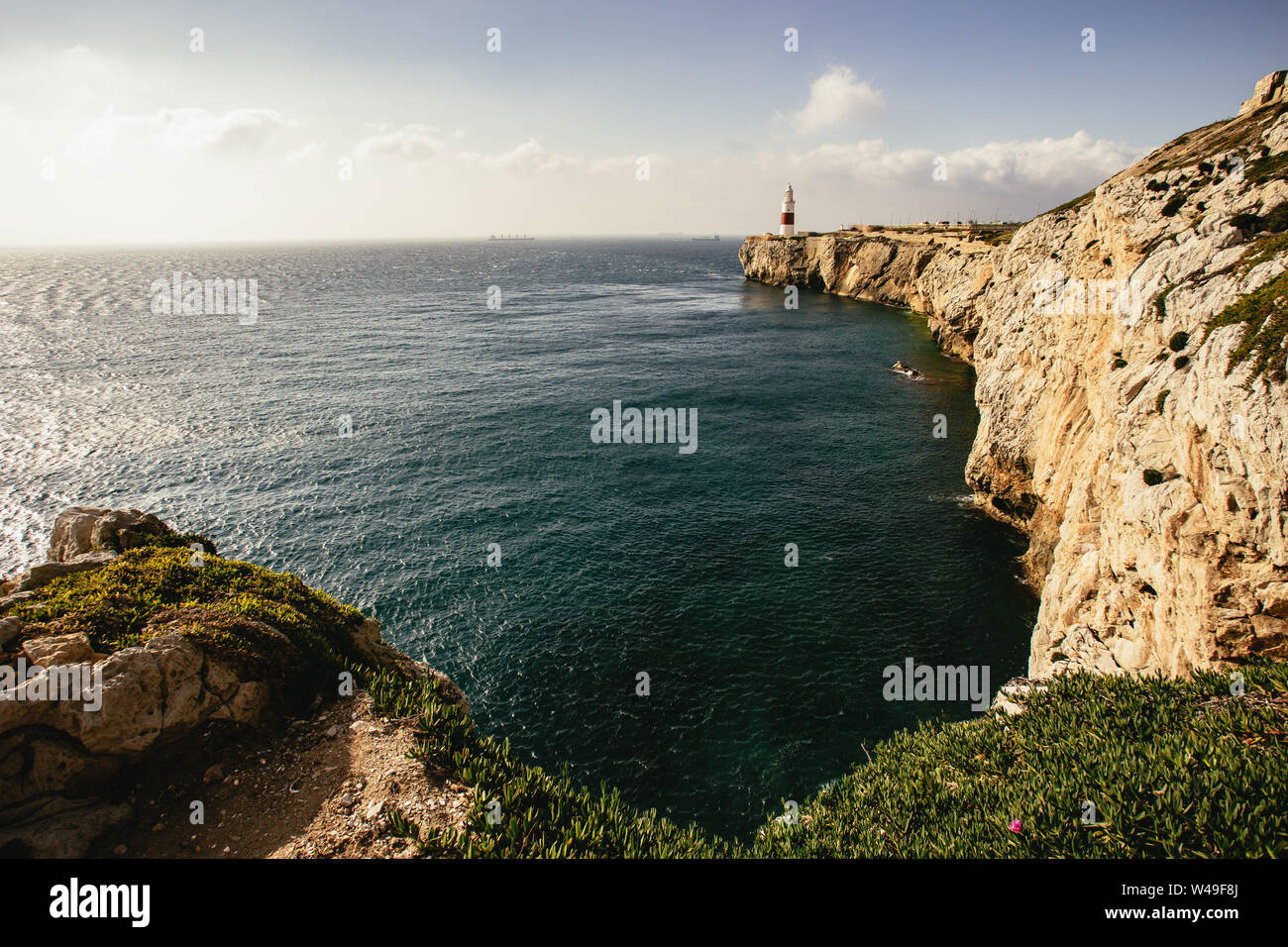 Jagged cliff towering alongside massive ocean Stock Photo - Alamy