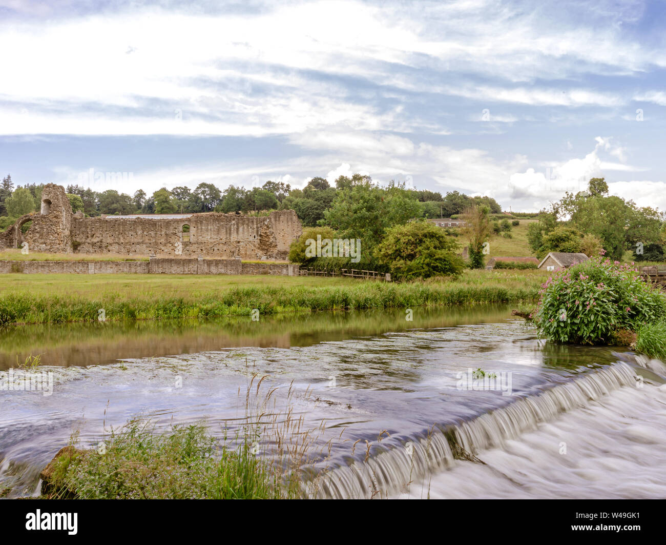 Water from the River Derwent rushes down a weir and the ruins of an ...