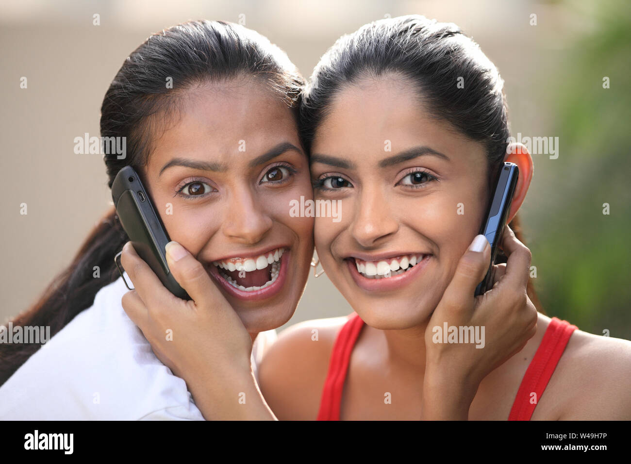 Two friends talking on mobile phone Stock Photo - Alamy