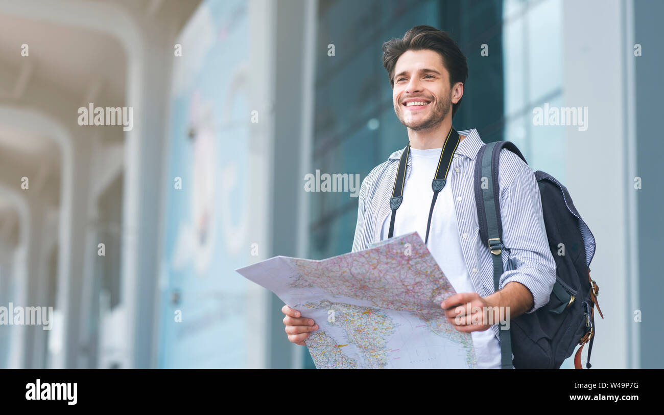 Tourist man looking for route on map at airport Stock Photo - Alamy