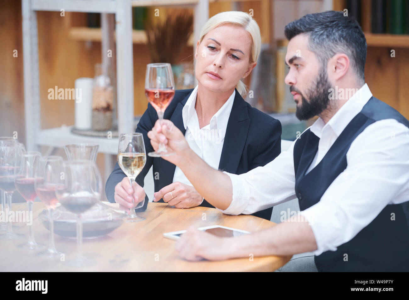 Serious and attentive sommeliers evaluating color of wine sample Stock ...