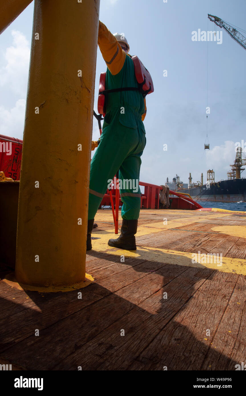 ship crew stand by on deck to received cargo lift to the boat by crane ...