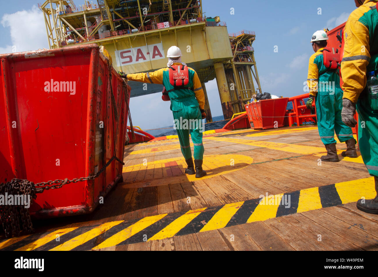 ship crew stand by on deck to received cargo lift to the boat by crane ...