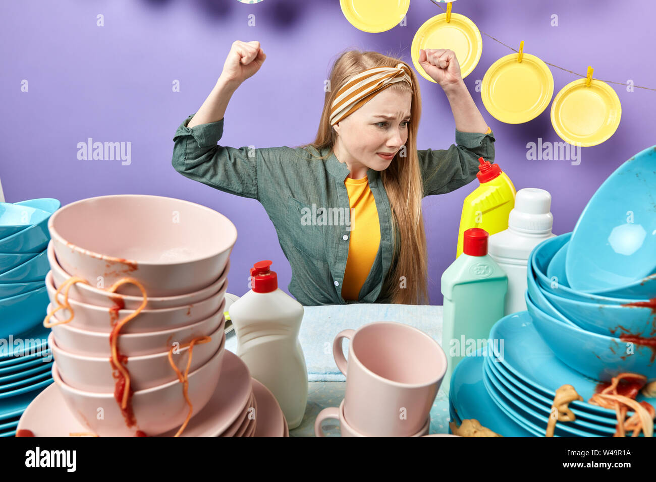 angry frustrated young woman with clenched raised fists sitting behind ...