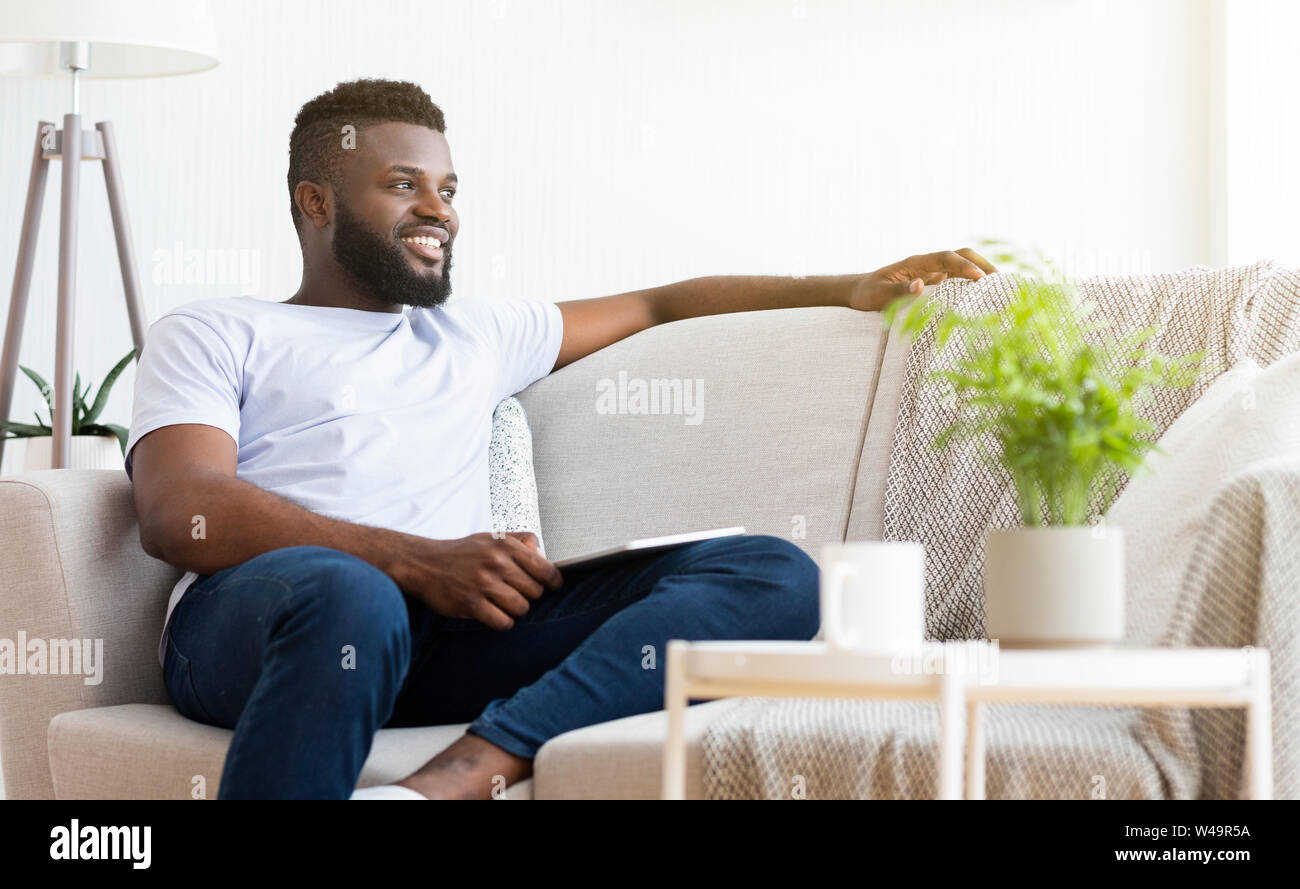 Comfortable weekend. Peaceful african man resting at home Stock Photo ...