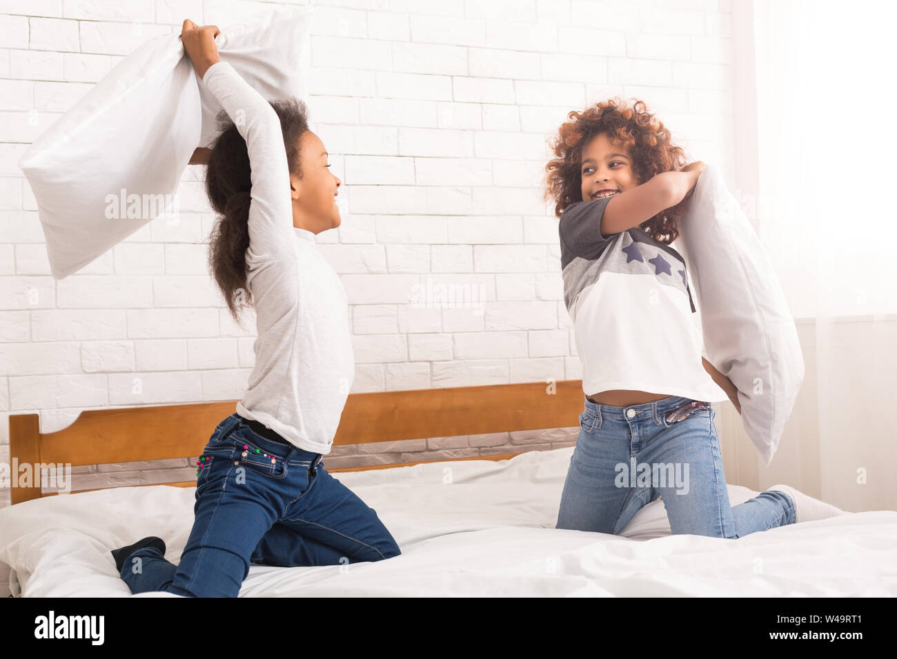 Best friends fighting with pillows, having fun Stock Photo - Alamy