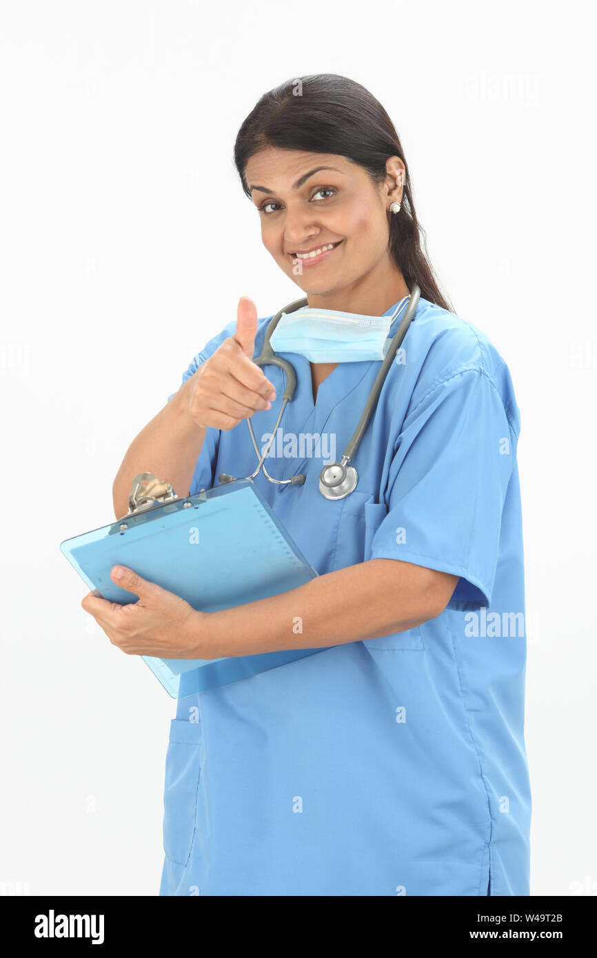 Female doctor showing thumbs up sign and smiling Stock Photo - Alamy