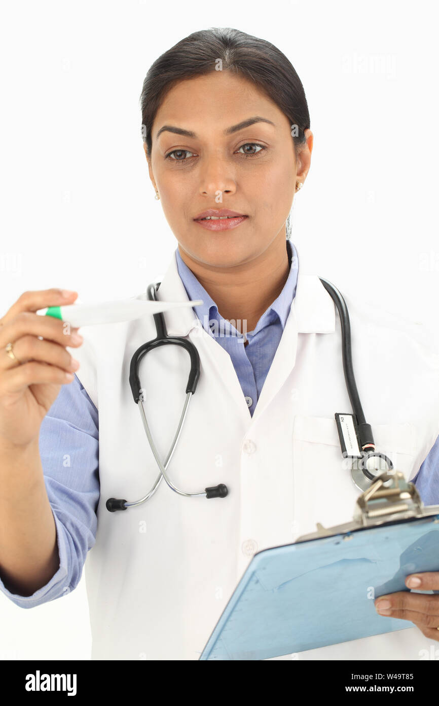 Female doctor checking temperature in digital thermometer Stock Photo ...