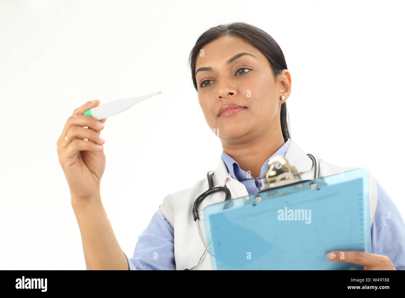 Indian female doctor checking temperature in digital thermometer Stock ...