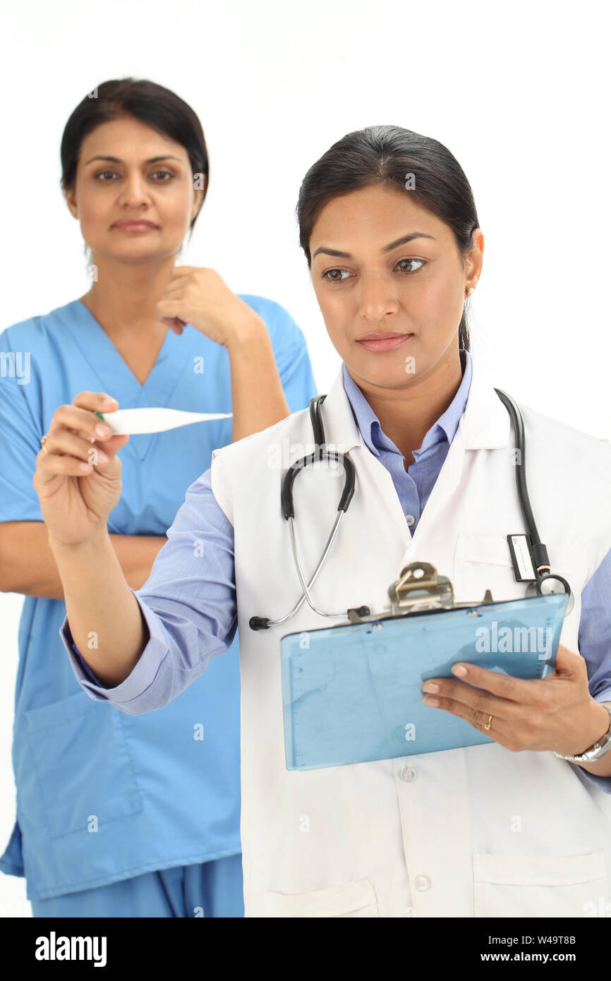 Female doctor checking temperature in digital thermometer Stock Photo ...