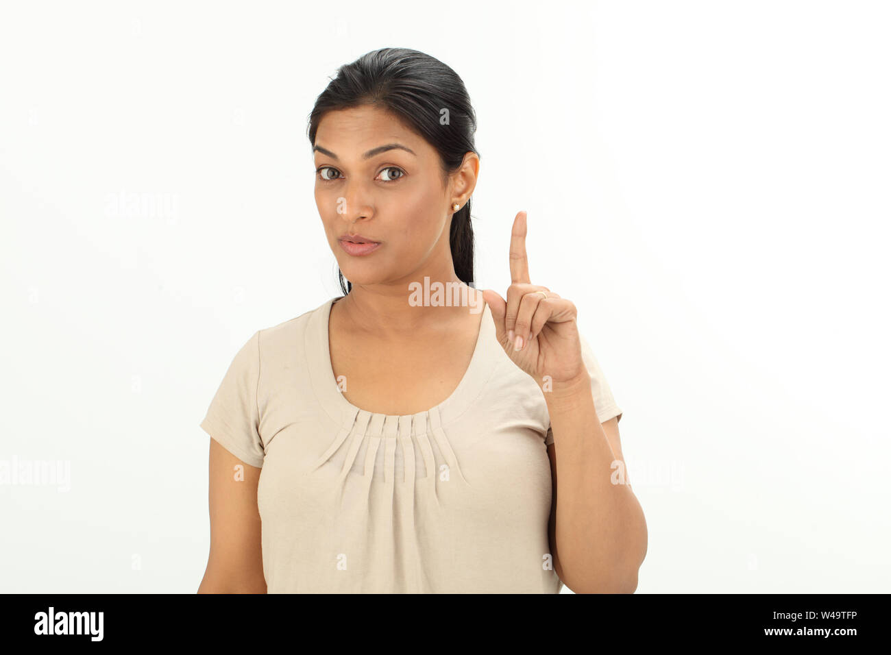 Portrait of a woman pointing upward Stock Photo - Alamy