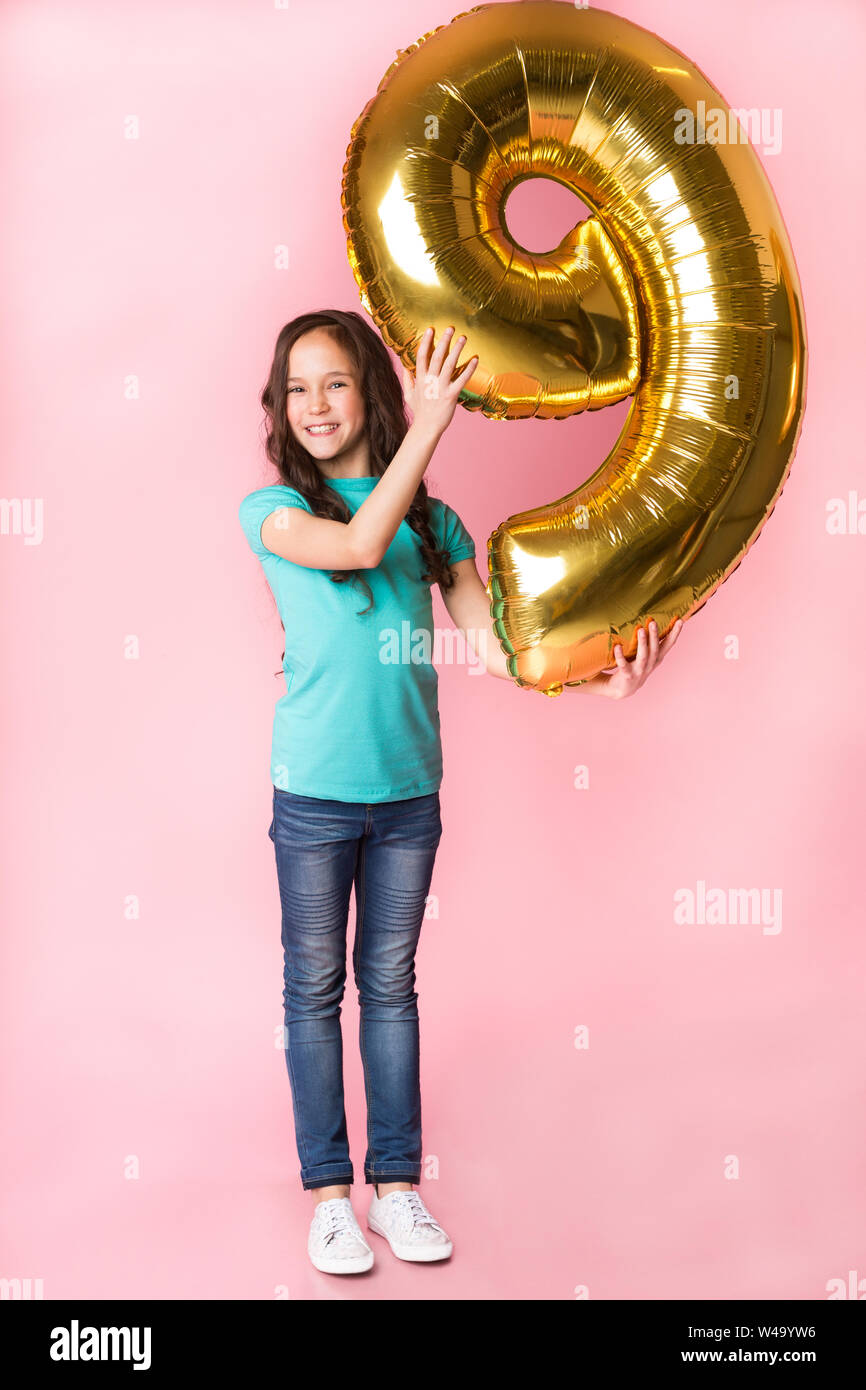 Excited girl with number 9 balloon at studio background Stock Photo - Alamy