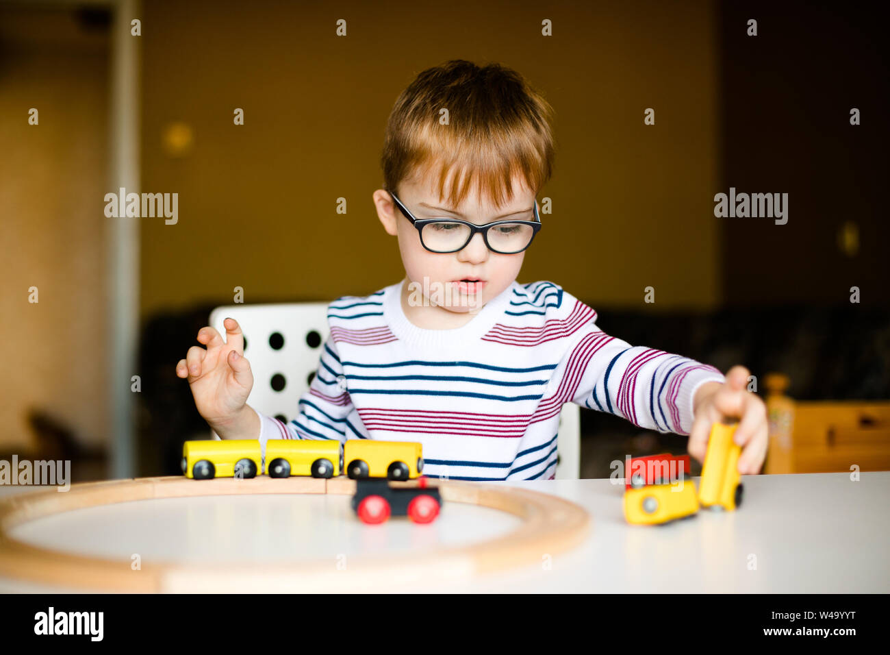 little ginger boy with glasses with syndrome dawn playing with train ...