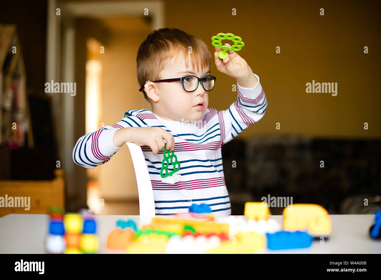 little ginger boy with glasses with syndrome dawn playing with color ...