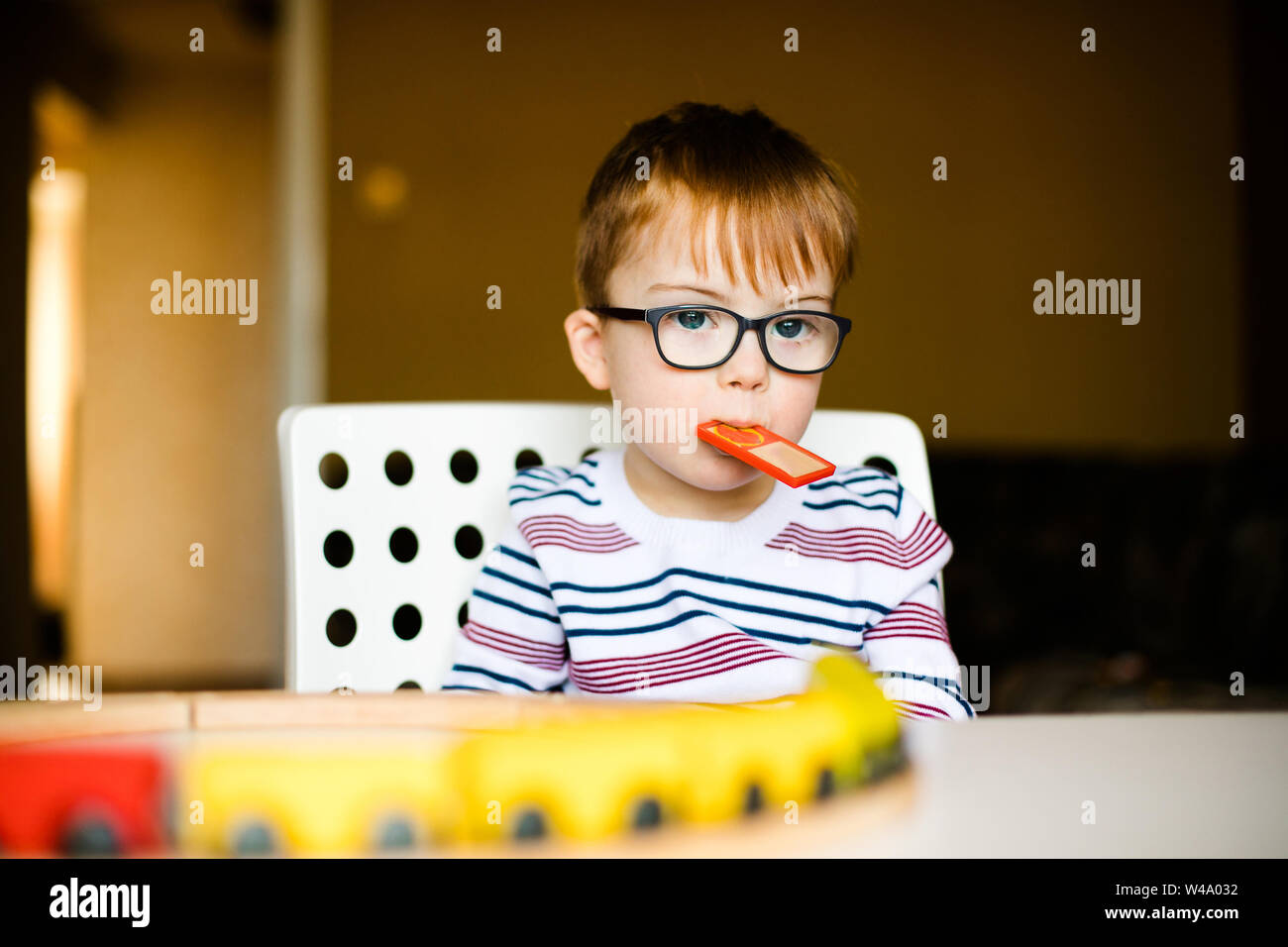 little ginger child boy in the glasses with syndrome dawn playing with ...