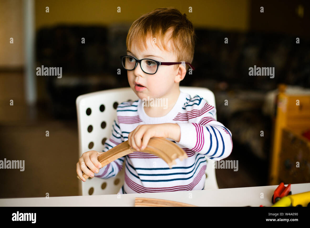 little ginger child boy in the glasses with syndrome dawn playing with ...