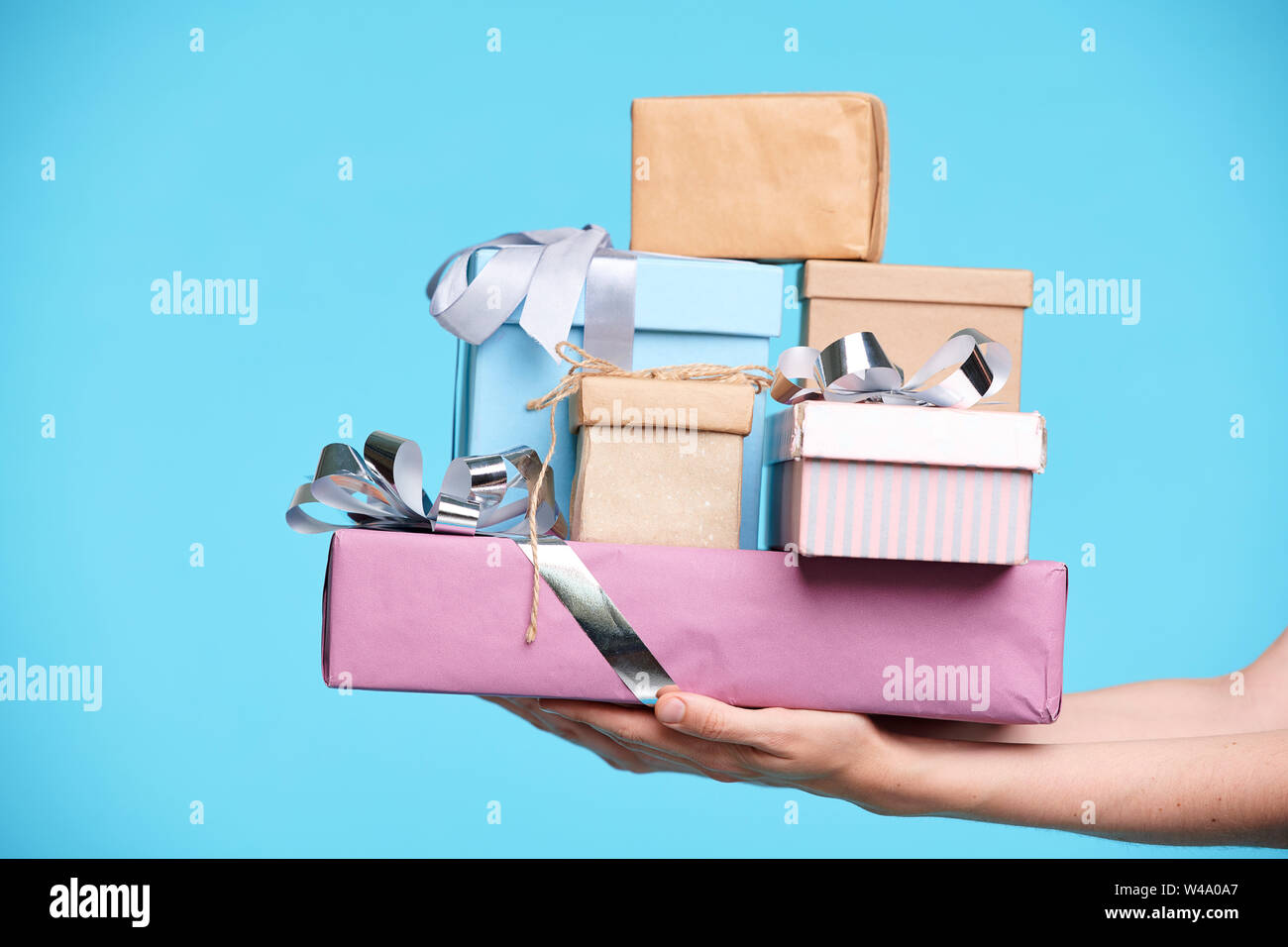 Stack of packed and wrapped presents in boxes held by female hands ...