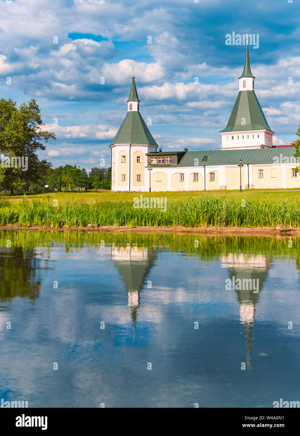 Monastery wall and towers on shore of lake in Russia. Blue cloudy sky ...