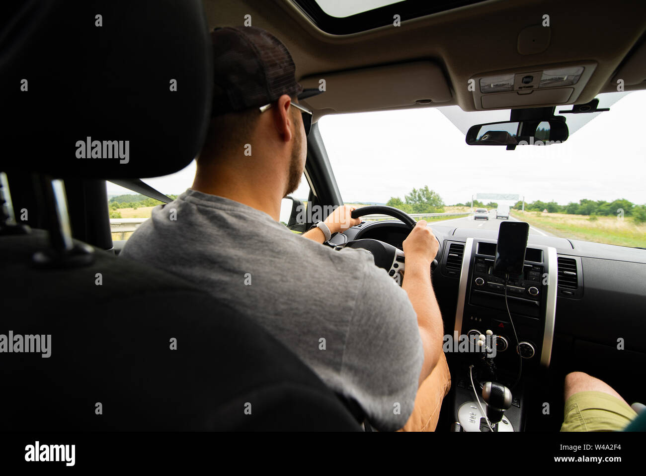 car travel concept view from inside young caucasian man driving car by ...