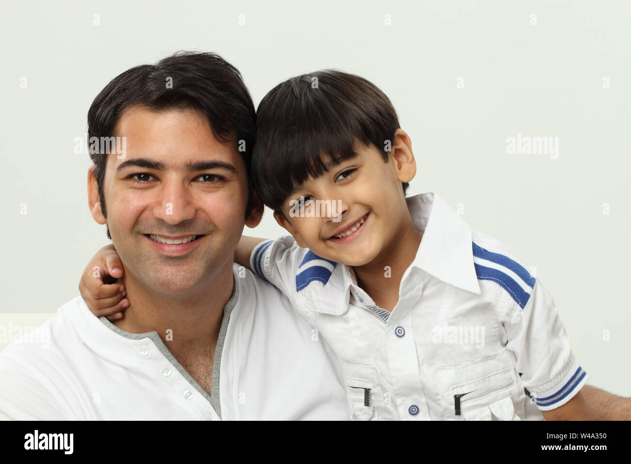 Boy hugging his father and smiling at home Stock Photo - Alamy