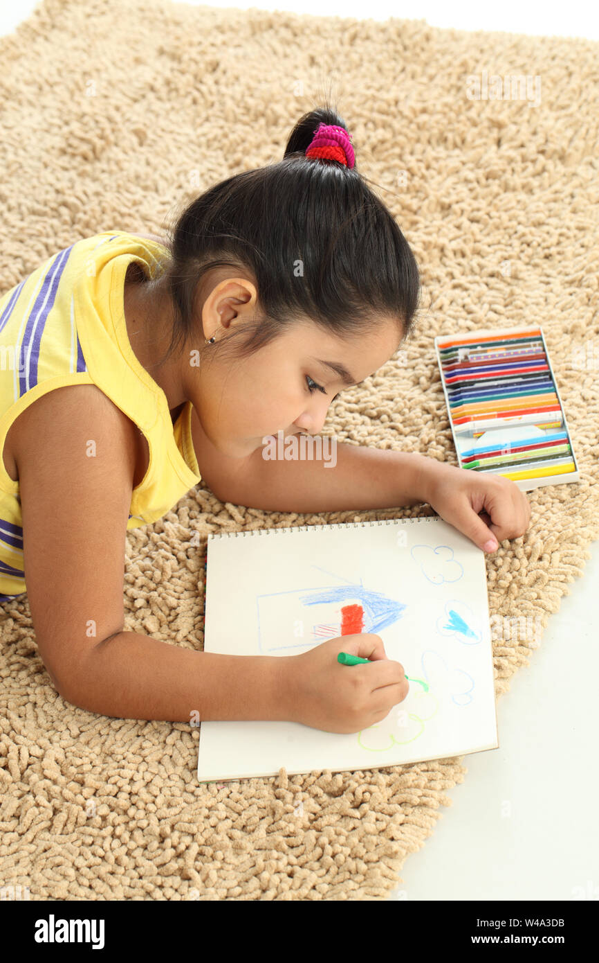 Girl lying on floor drawing in a sketch book Stock Photo - Alamy