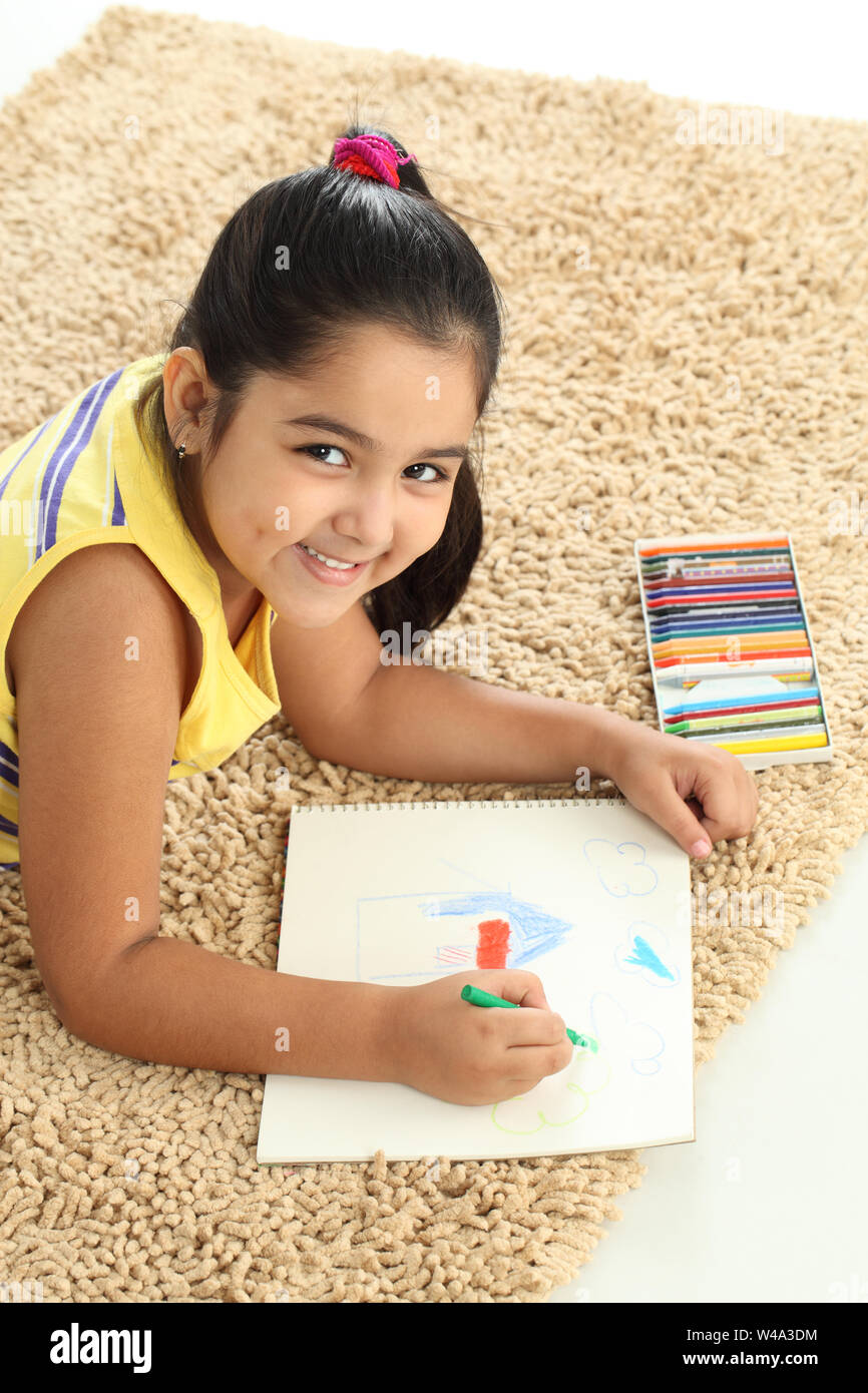 Girl lying on floor drawing in a sketch book Stock Photo - Alamy